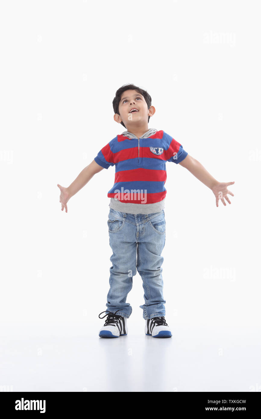Boy standing with arm outstretched and smiling Stock Photo - Alamy