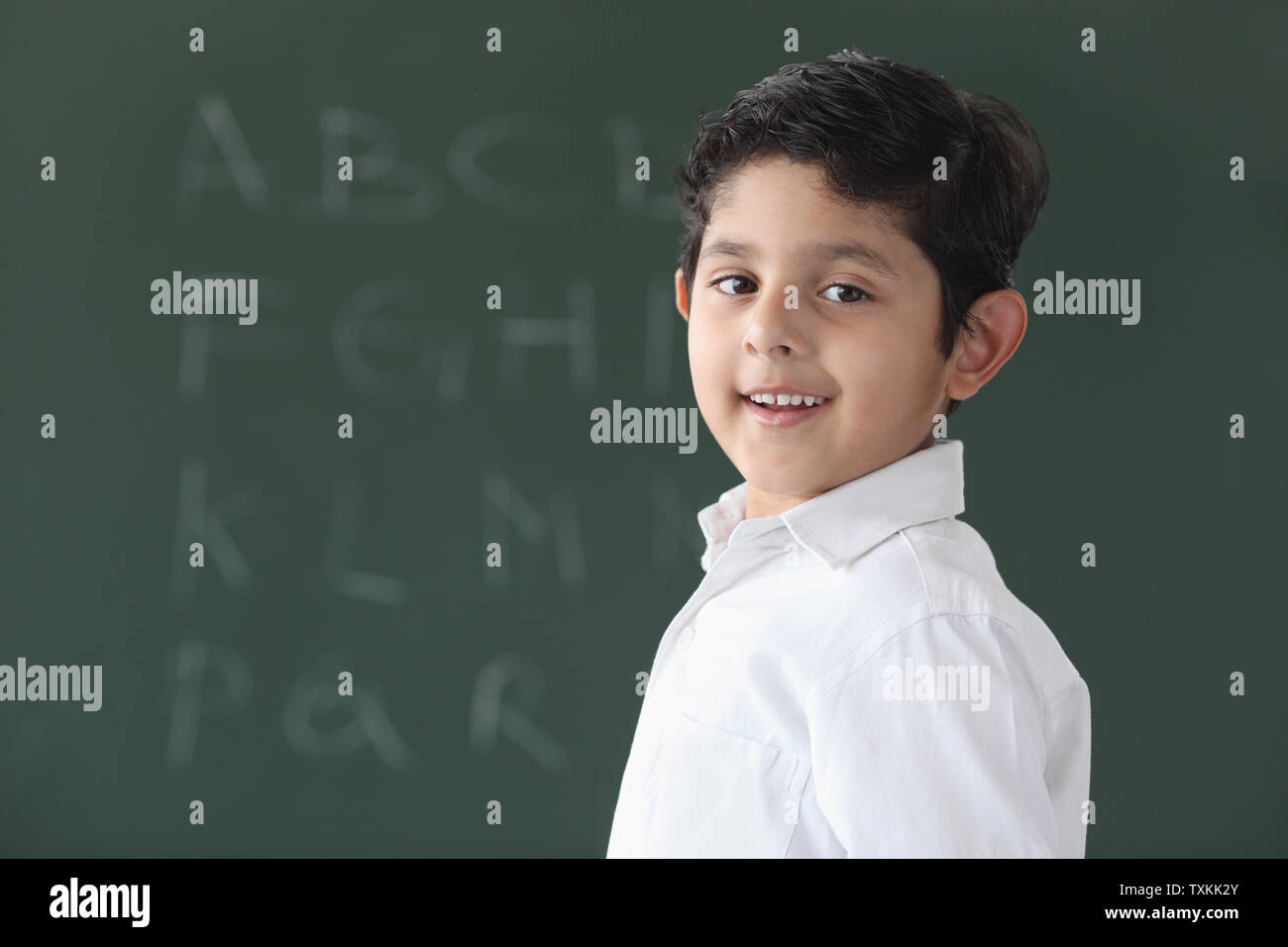 Schoolboy smiling in a classroom Stock Photo - Alamy