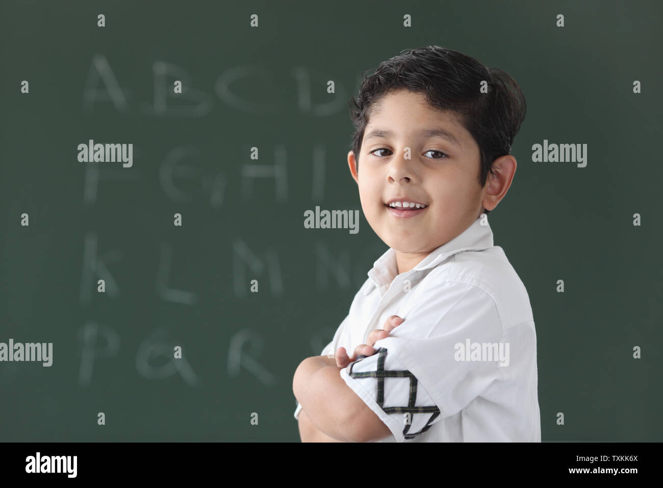 Schoolboy smiling in a classroom Stock Photo - Alamy