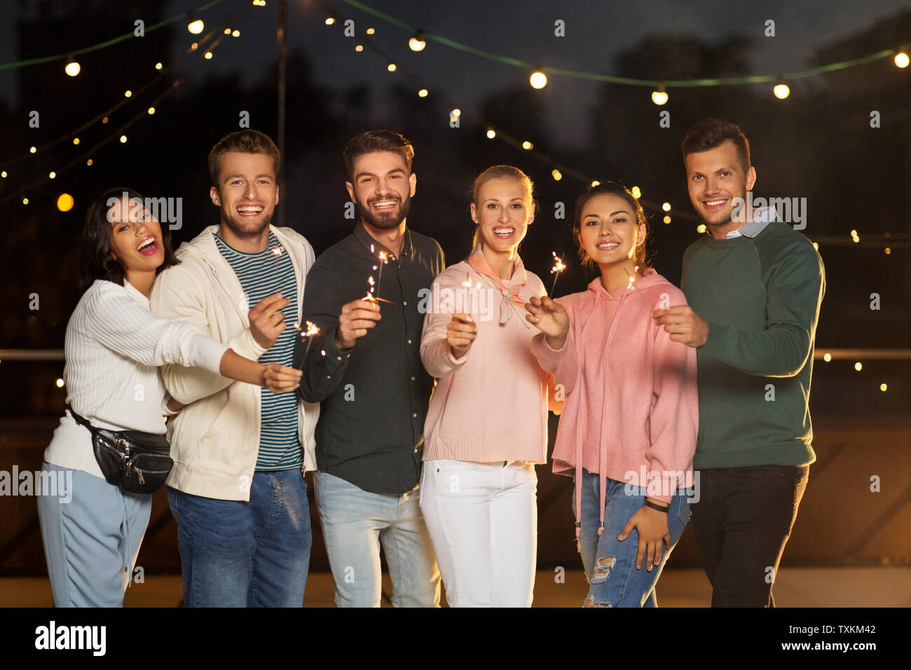 happy friends with sparklers at rooftop party Stock Photo - Alamy