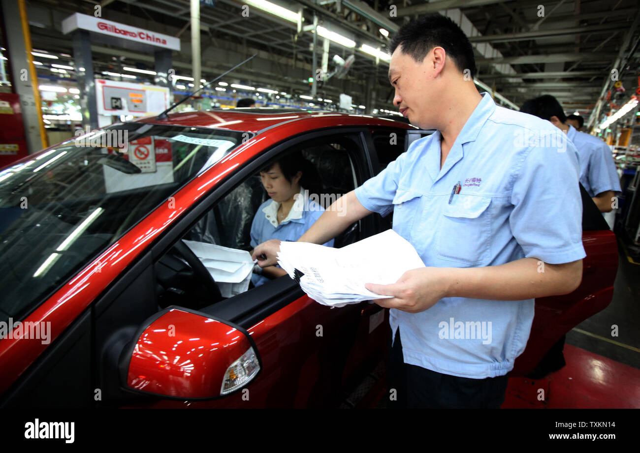 Chinese workers assemble Ford and Volvo cars at a Chang'an Ford ...