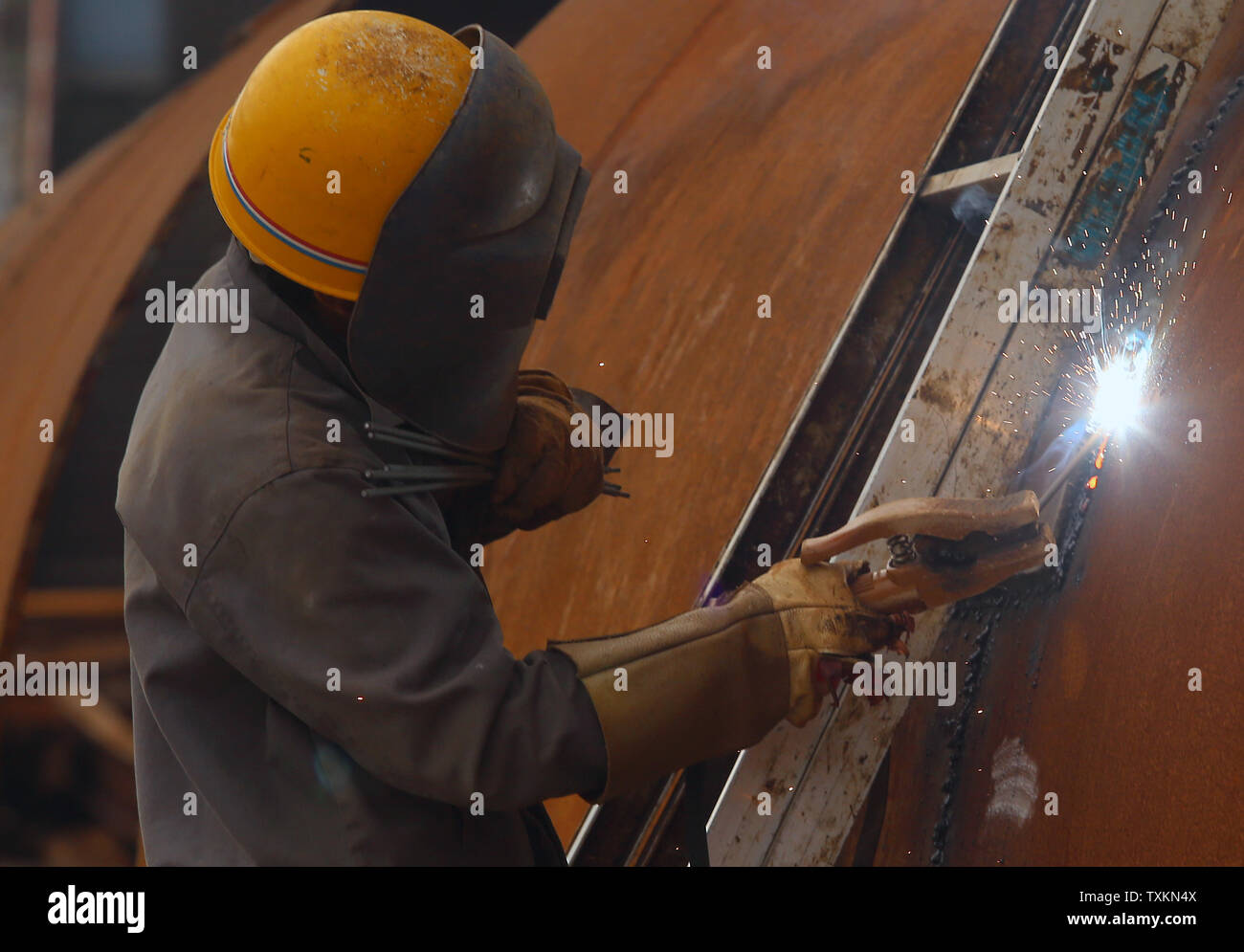 A Chinese welder connects segments of a huge steel pipe in Chongqing ...