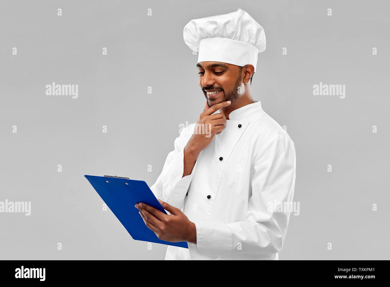 happy indian chef reading menu on clipboard Stock Photo - Alamy