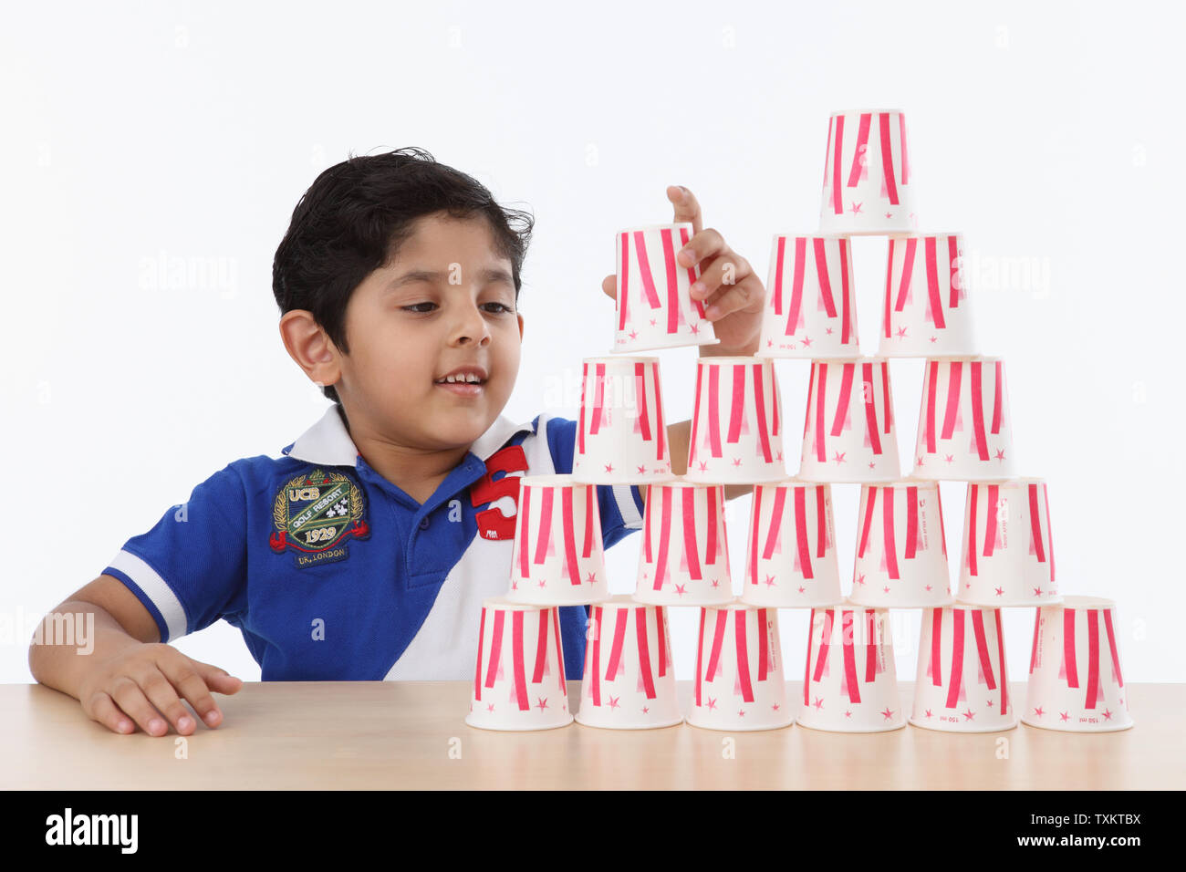 Boy building a disposable cups house Stock Photo - Alamy