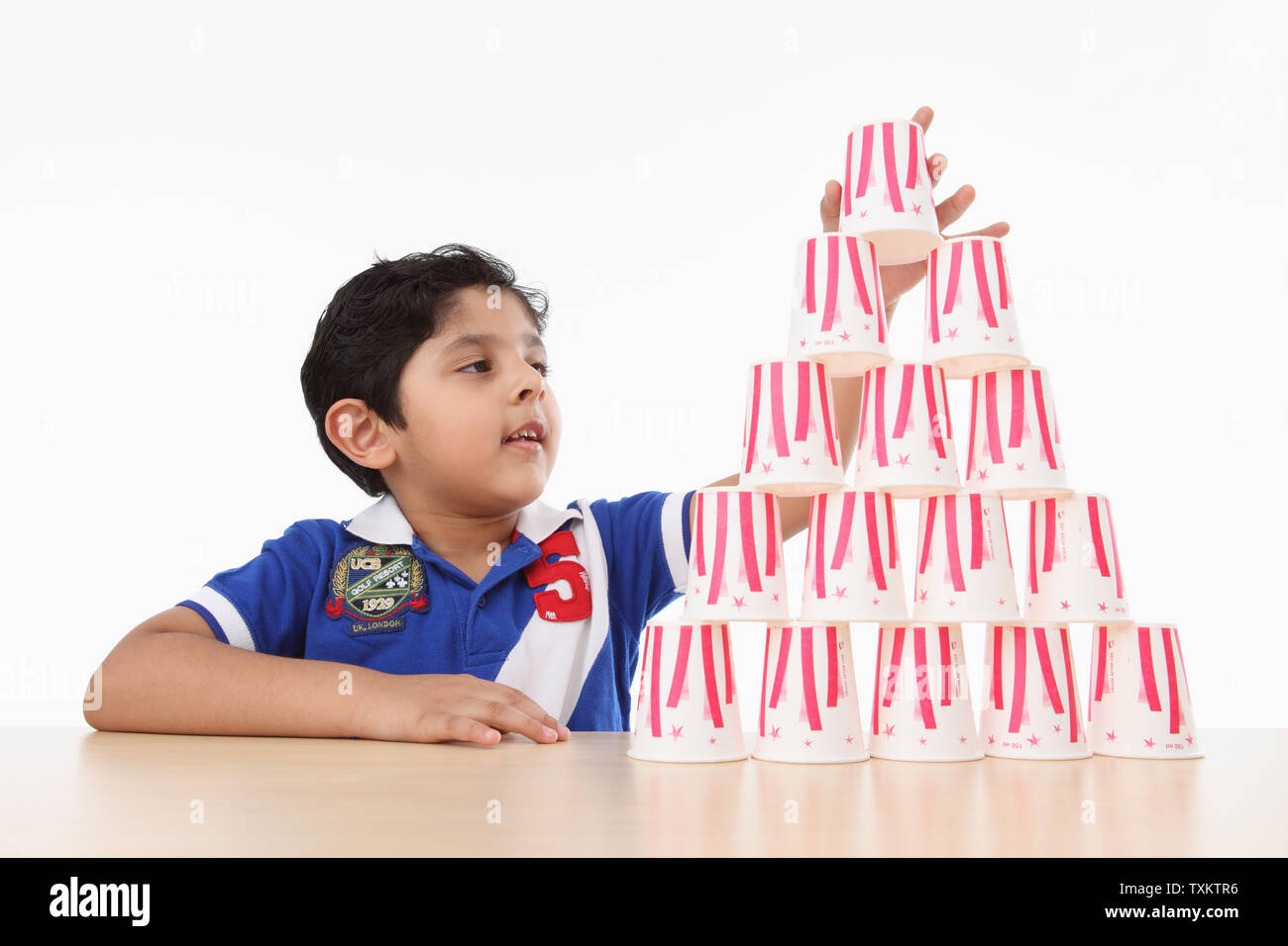 Boy building a disposable cups house Stock Photo - Alamy