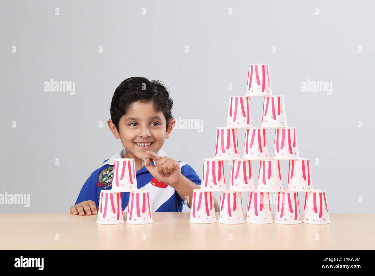 Boy building a disposable cups house Stock Photo - Alamy