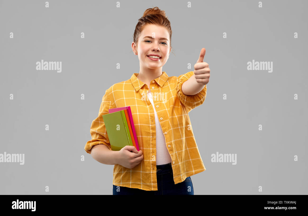 teenage student girl with books showing thumbs up Stock Photo - Alamy