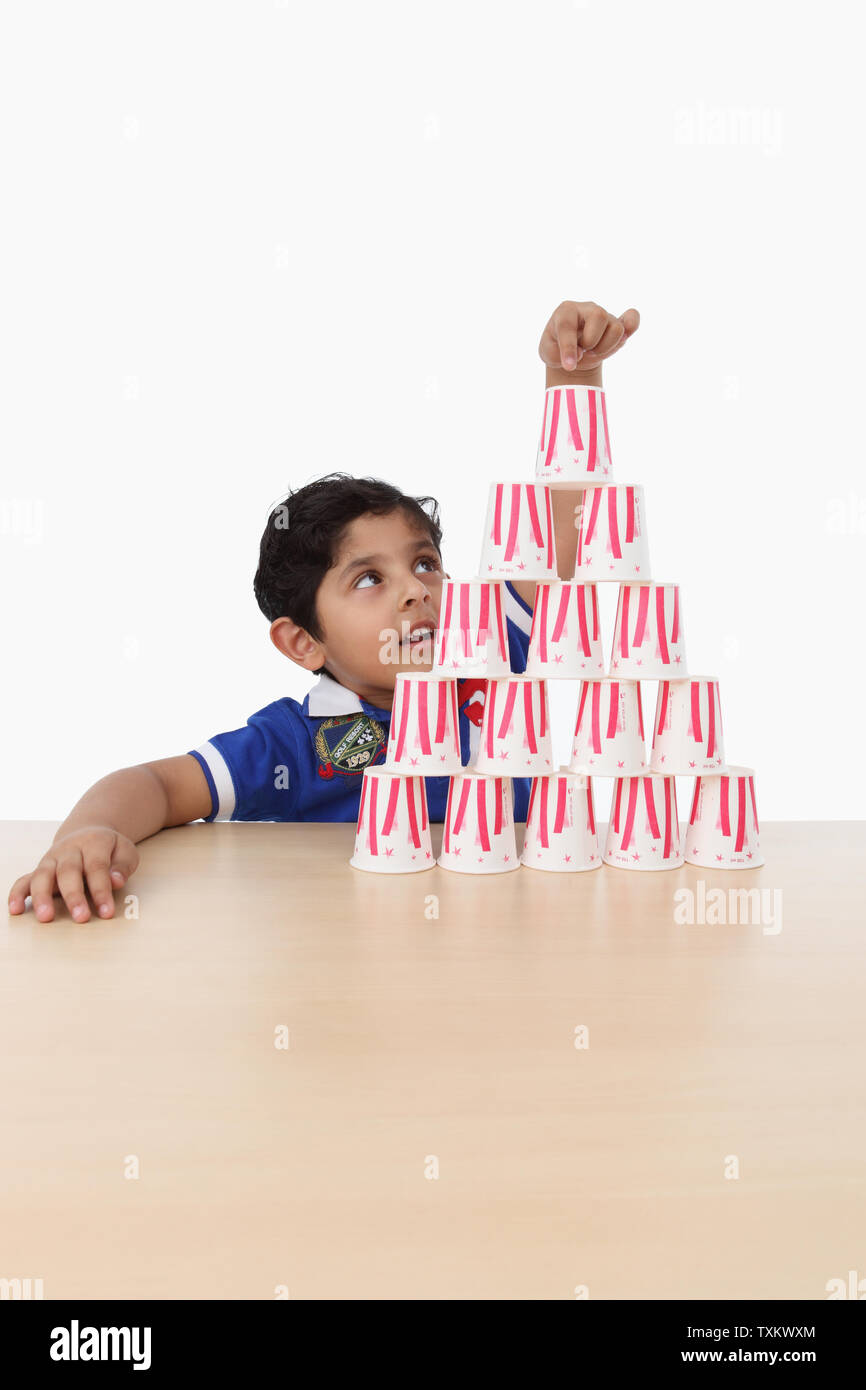 Boy building a disposable cups house Stock Photo - Alamy