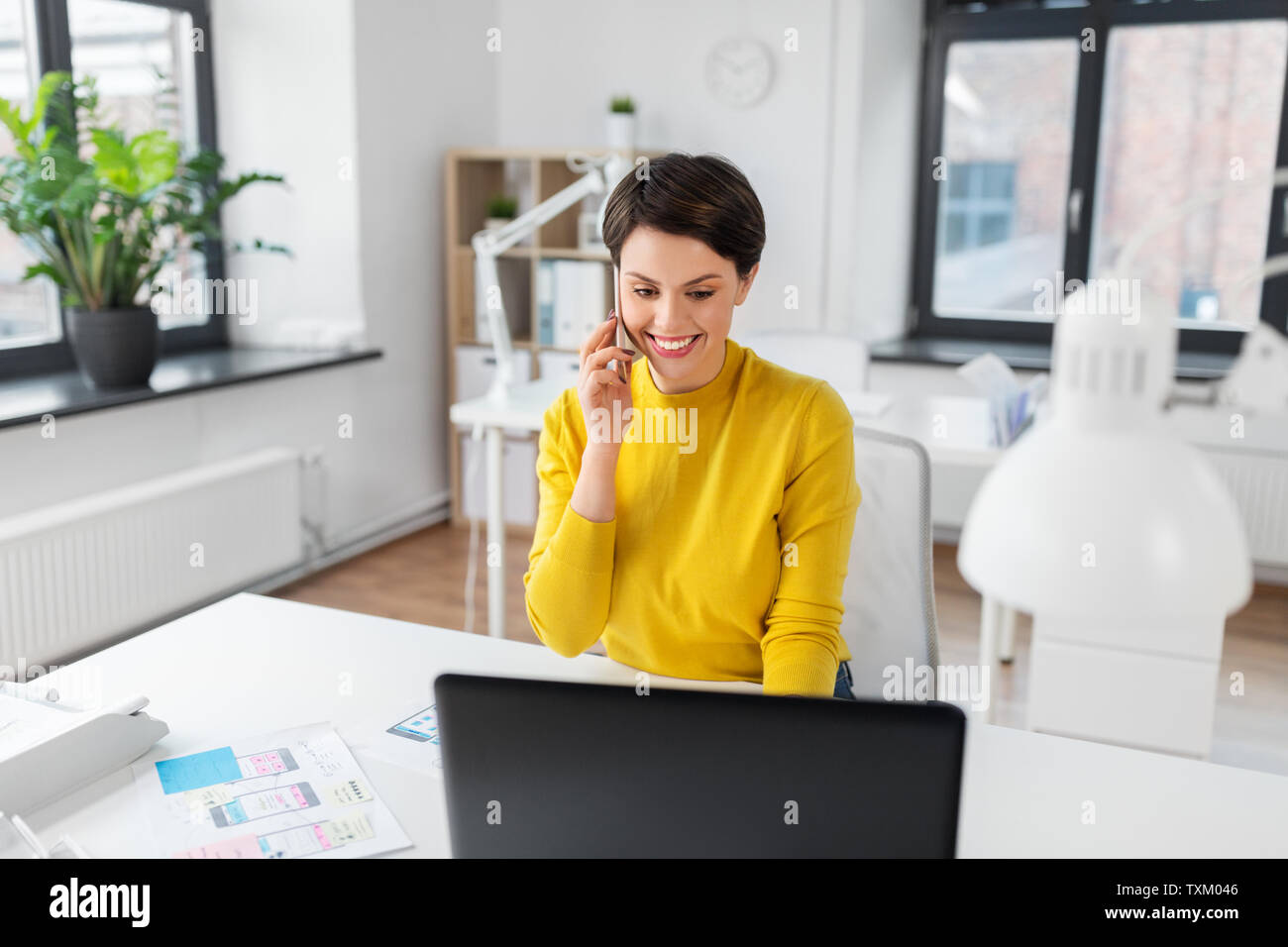 happy ui designer calling on smartphone at office Stock Photo - Alamy