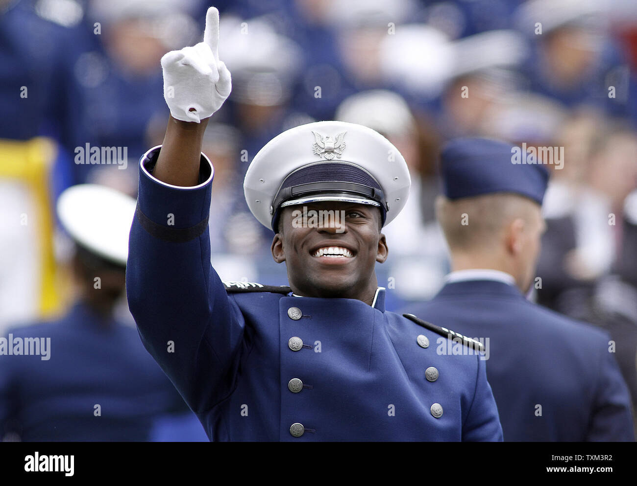 An Air Force cadet acknowledges his family in the crowd after shaking ...