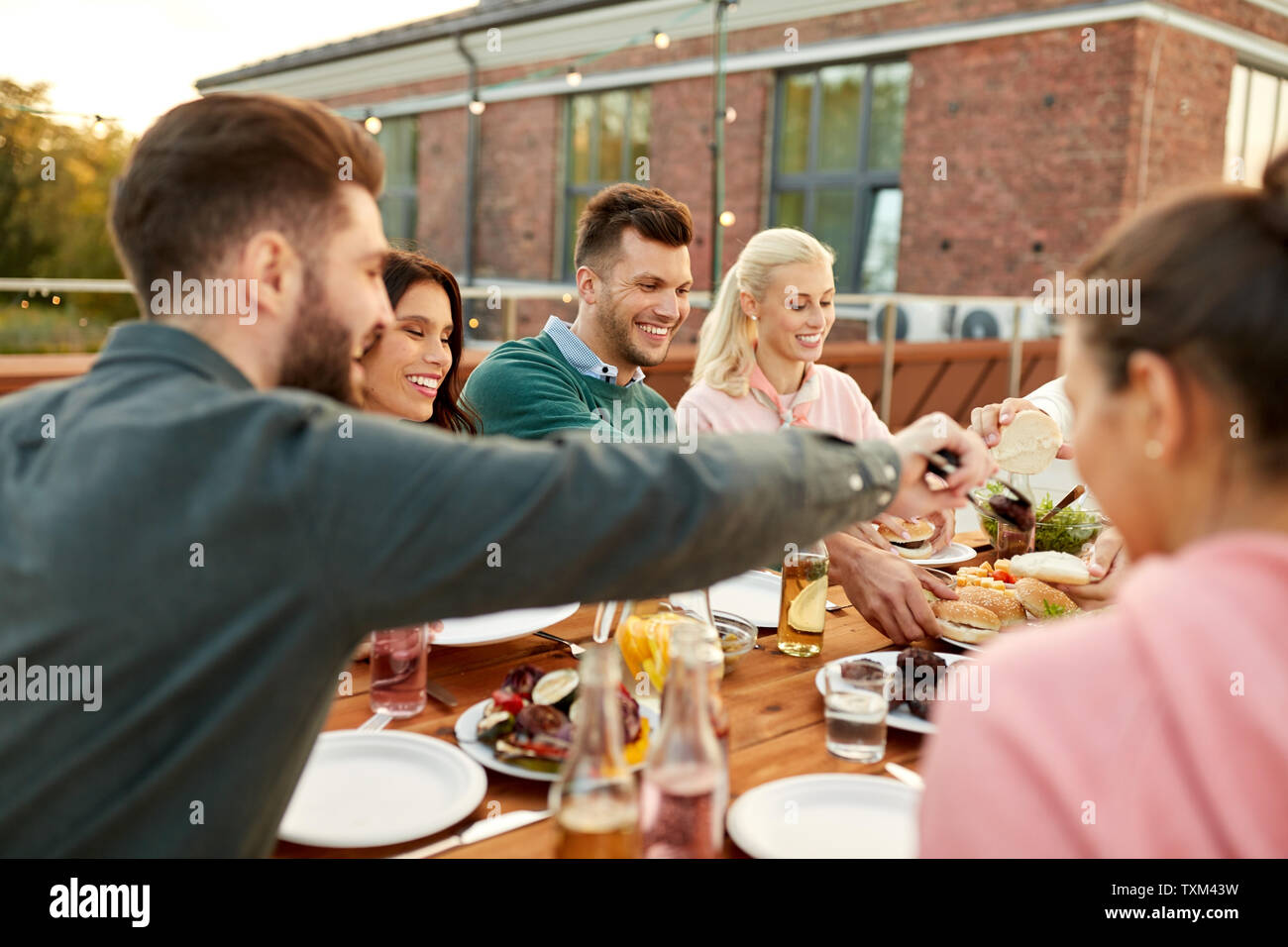 Family and friends hanging out eating and drinking hi-res stock ...