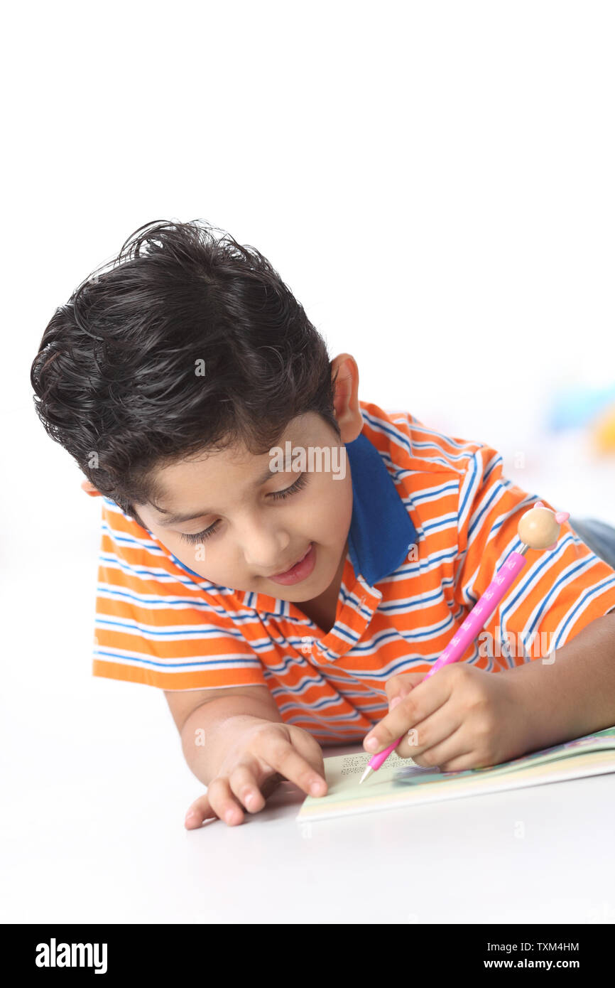 Boy writing in a notebook Stock Photo - Alamy