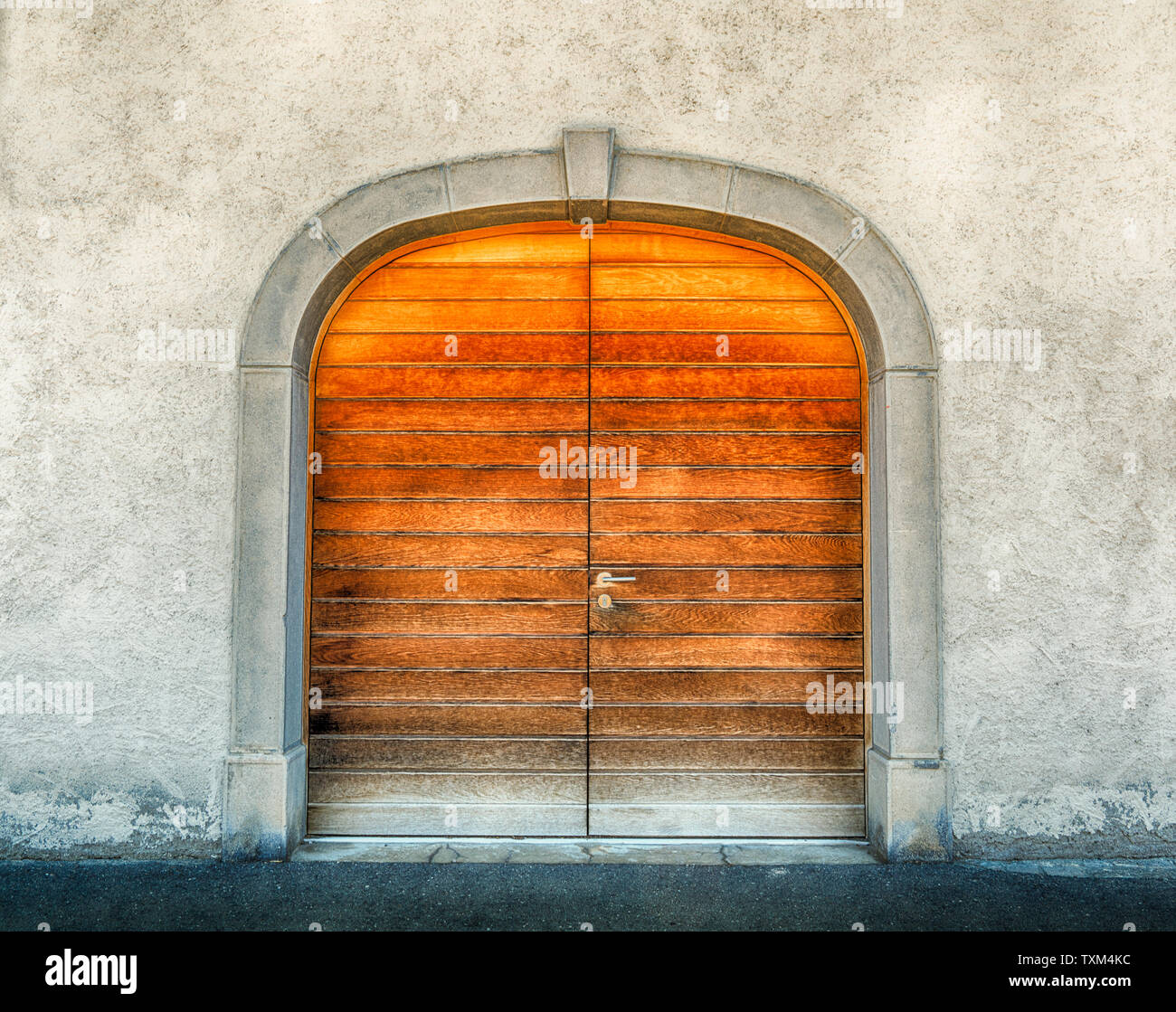 horizontal view of a massive winged wooden door in a stone wall with a ...