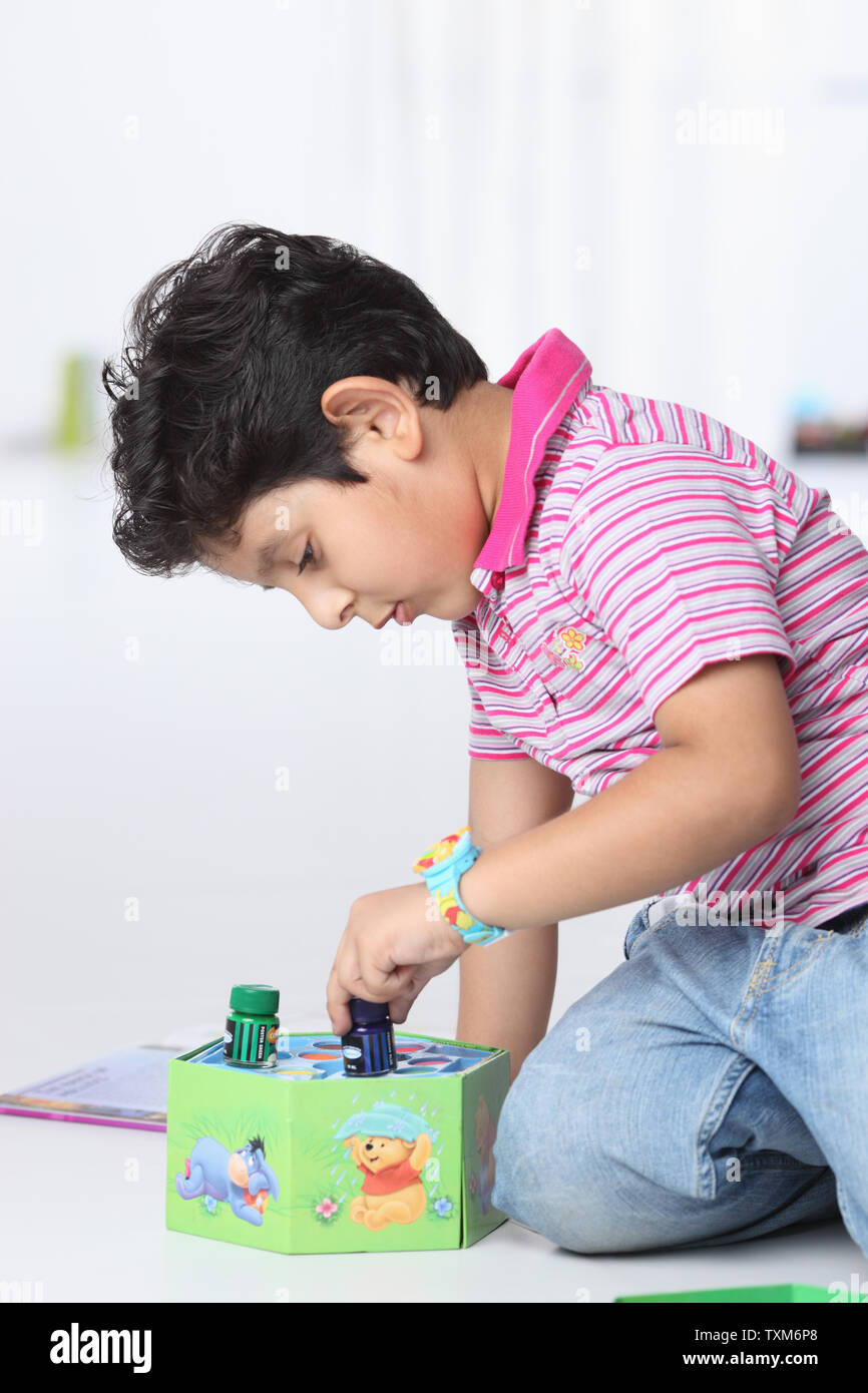 Boy putting poster colors in a box Stock Photo - Alamy