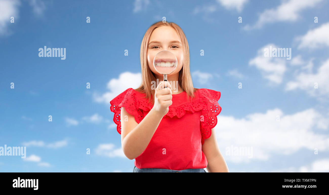 happy girl with magnifying glass over her teeth Stock Photo - Alamy