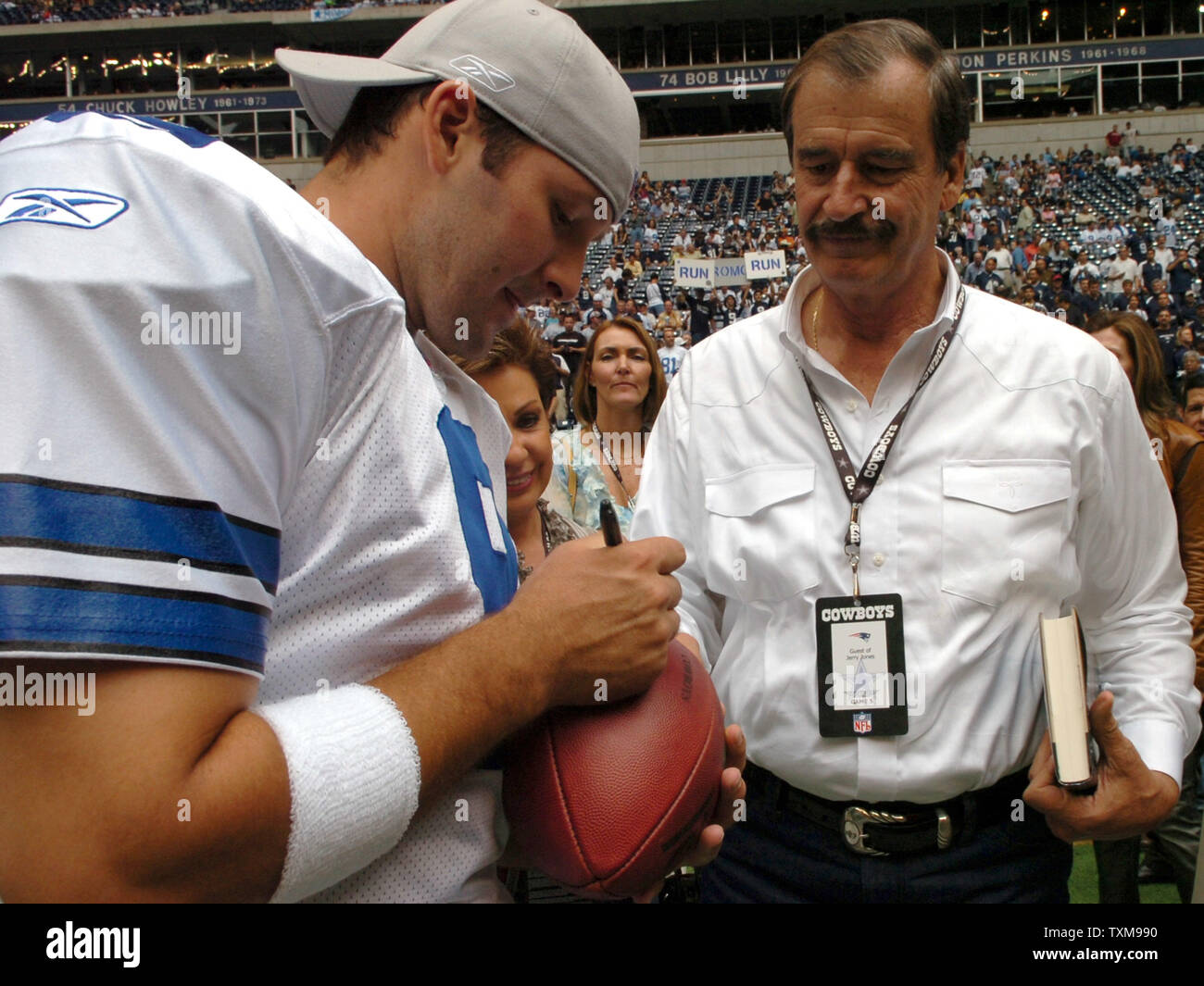 Dallas Cowboys quarterback Tony Romo autographs a football for former ...