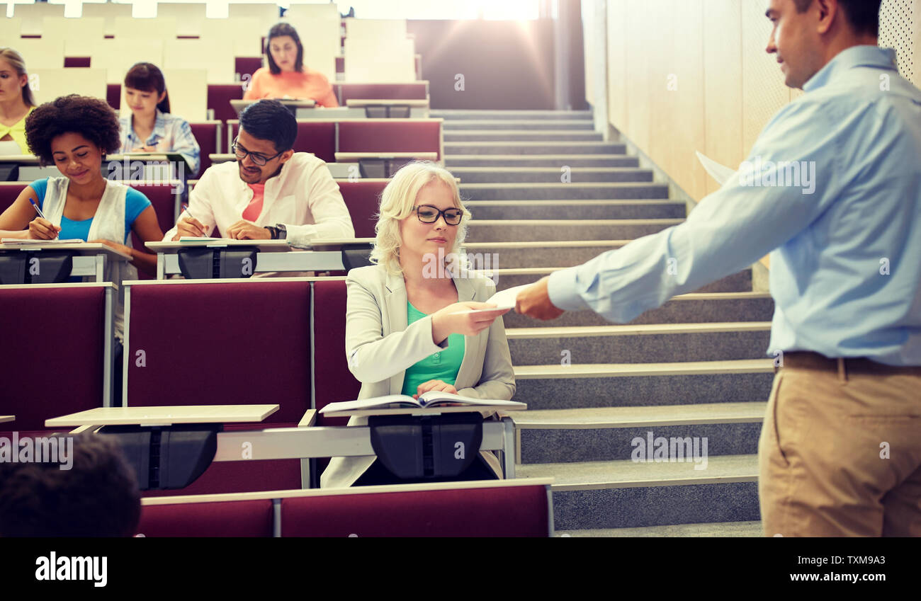 teacher giving exam tests to students at lecture Stock Photo - Alamy