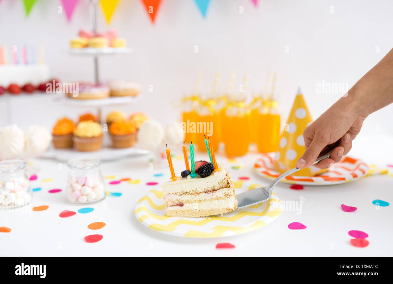 hand putting piece of birthday cake on plate Stock Photo - Alamy