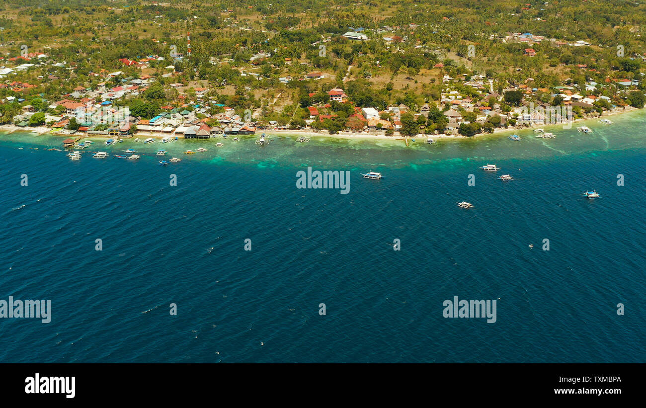 Shore with hotels near coral reef and diving boats, Moalboal ...