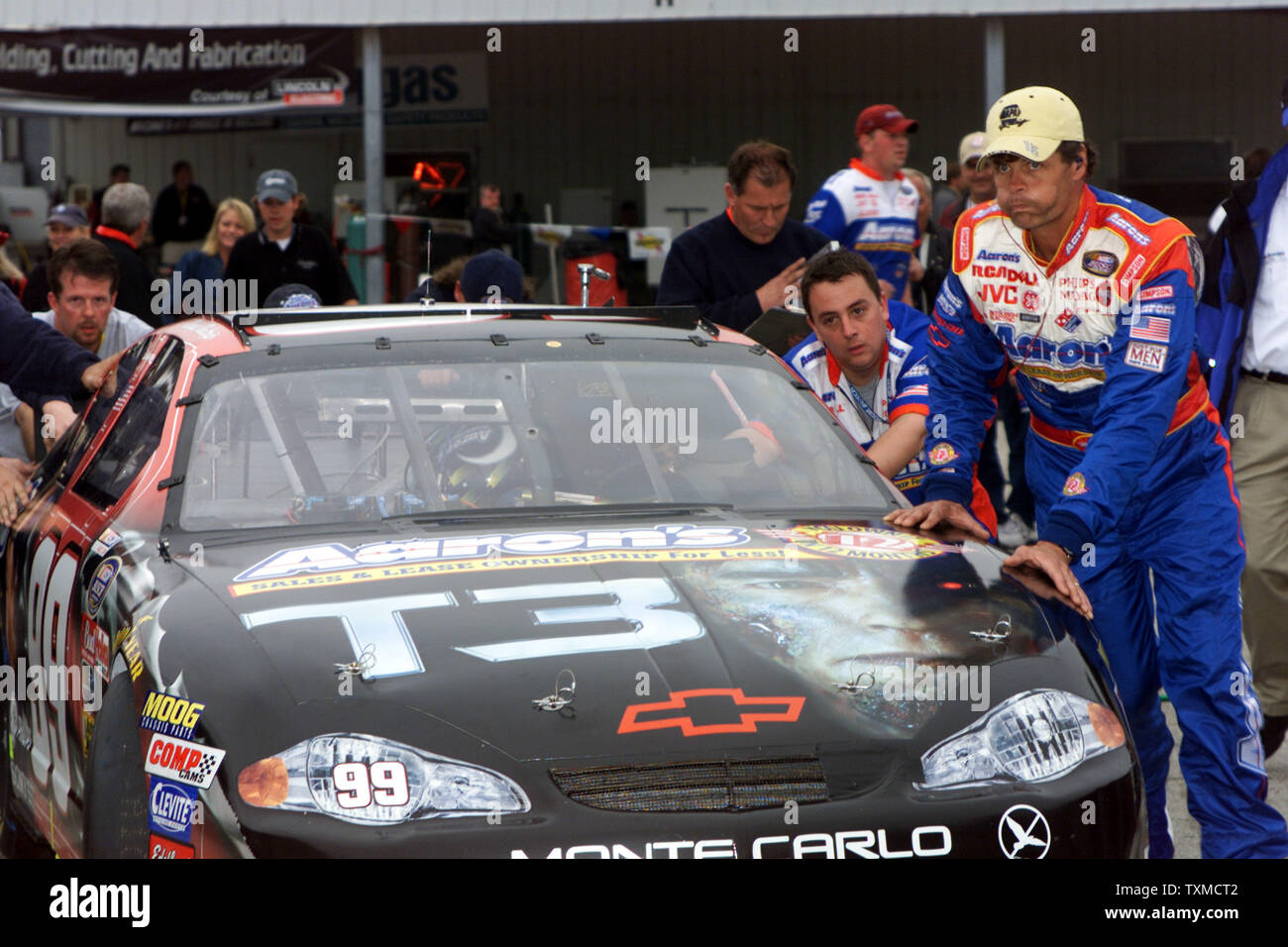 Michael Waltrip helps push his backup car after a wreck during practice ...