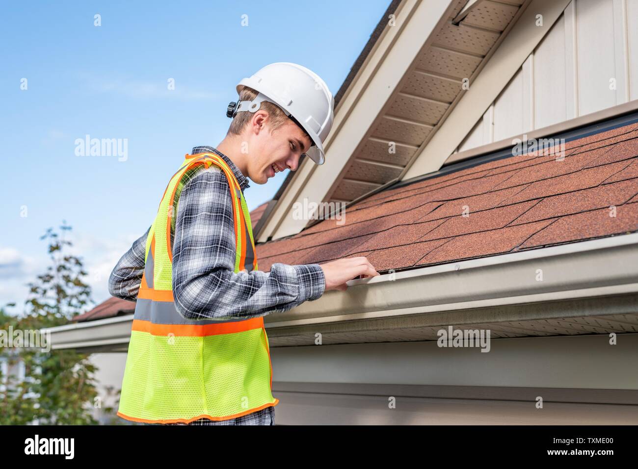 Home inspector standing on a ladder and providing an inspection to the ...