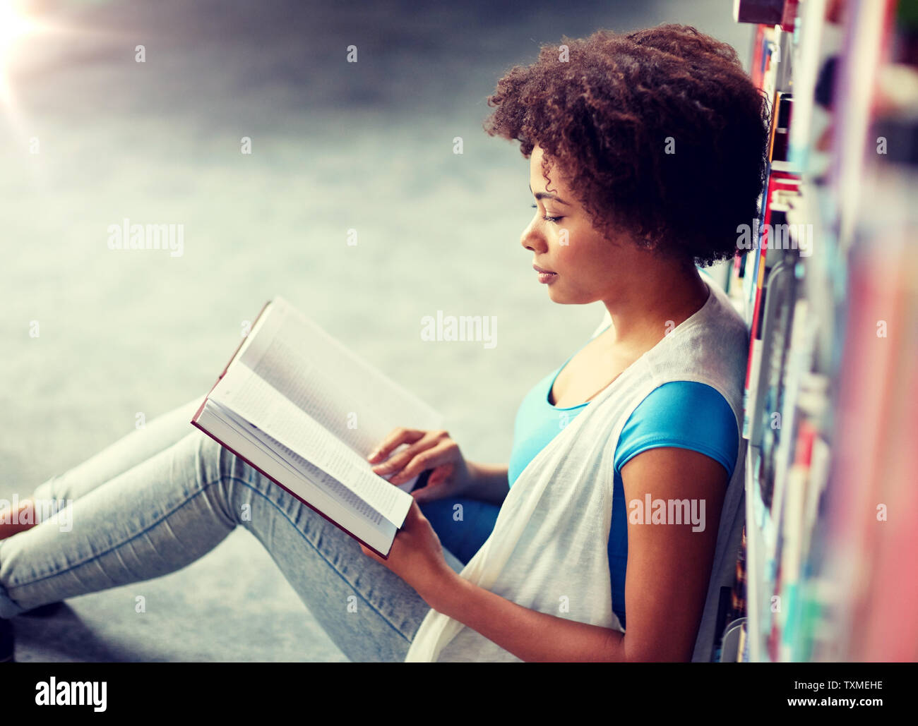 african student girl reading book at library Stock Photo - Alamy