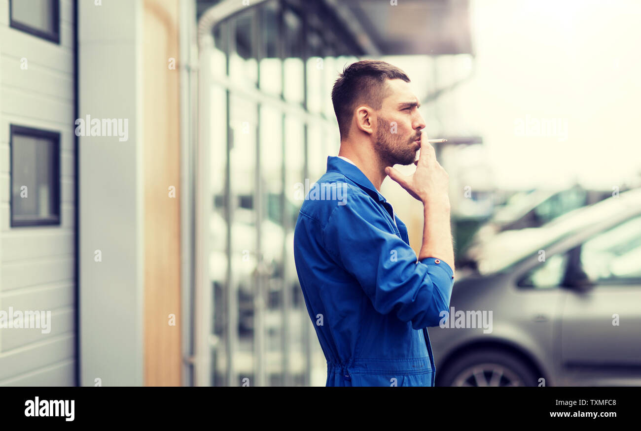 auto mechanic smoking cigarette at car workshop Stock Photo - Alamy