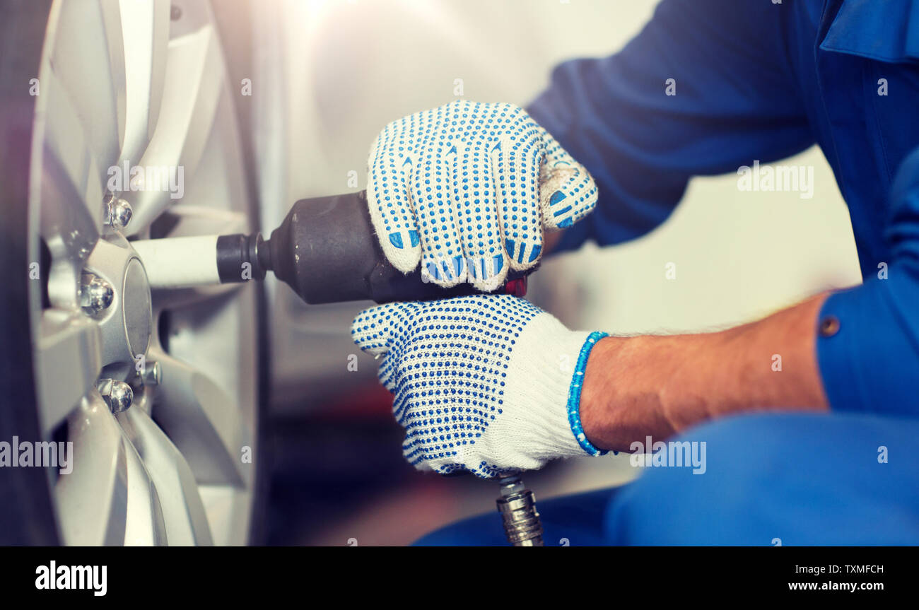 mechanic with screwdriver changing car tire Stock Photo - Alamy
