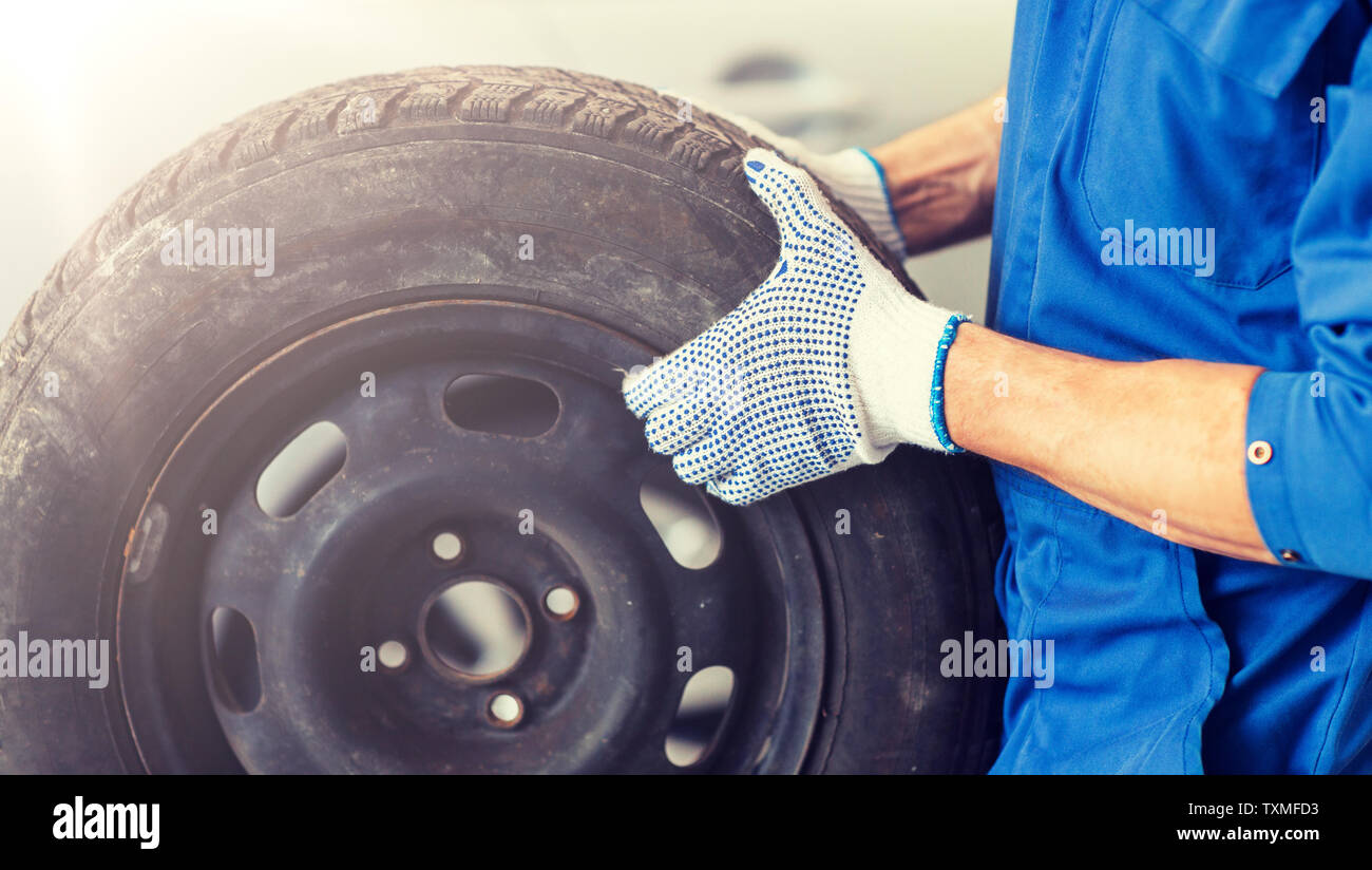 mechanic with wheel tire at car workshop Stock Photo - Alamy