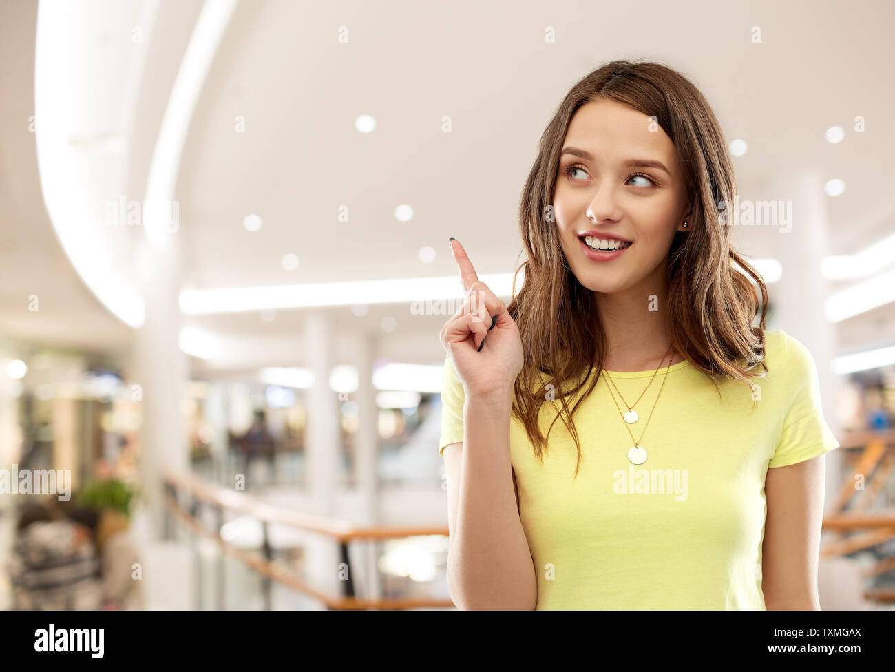 teenage girl pointing finger up in shopping mall Stock Photo - Alamy