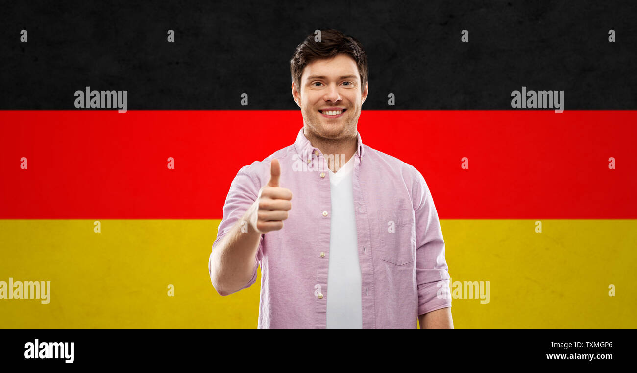 happy man showing thumbs up over german flag Stock Photo - Alamy