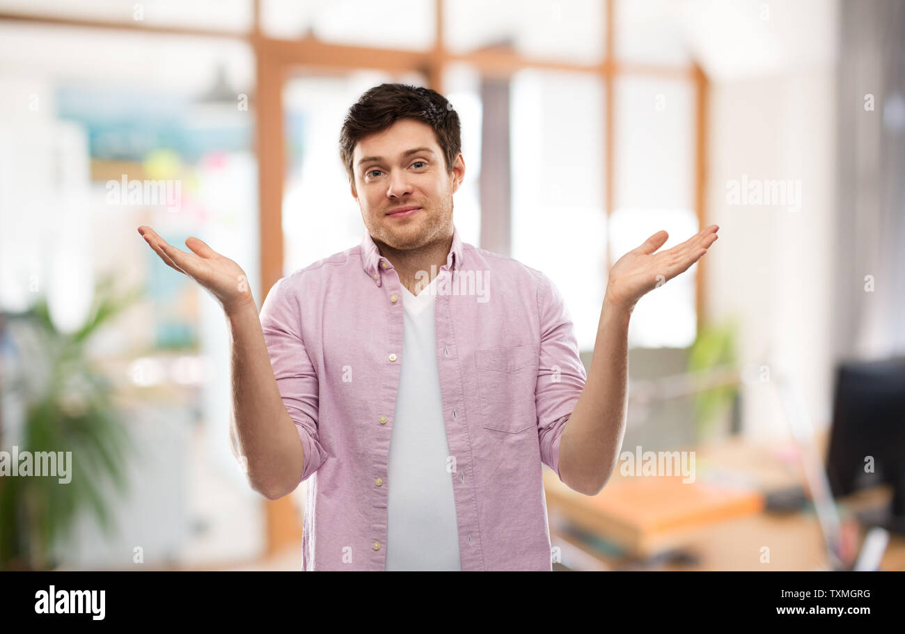 young man shrugging over office room Stock Photo - Alamy
