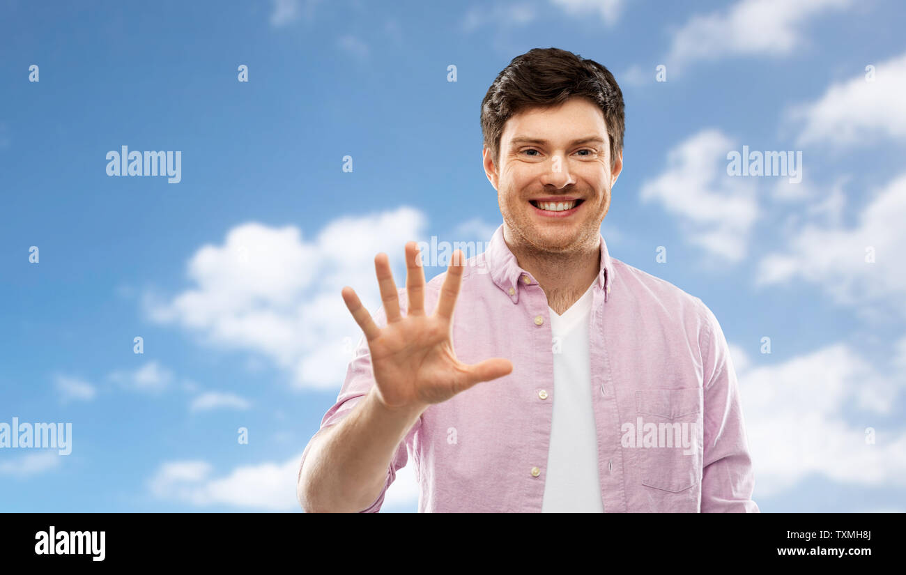 young man showing five fingers over sky Stock Photo - Alamy