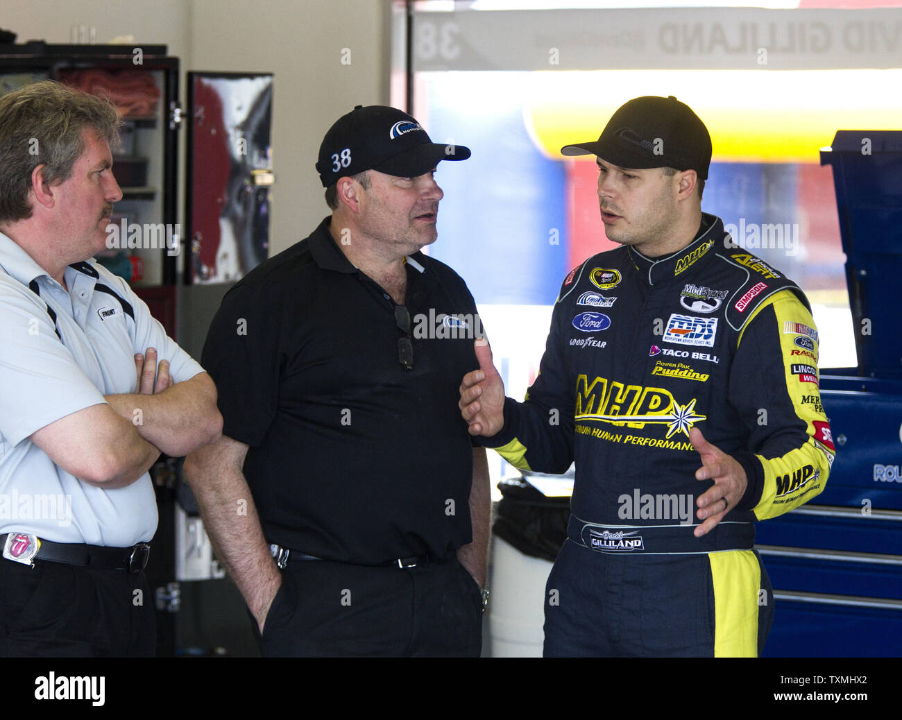 NASCAR driver David Gilliand (right) talks to crew members during ...