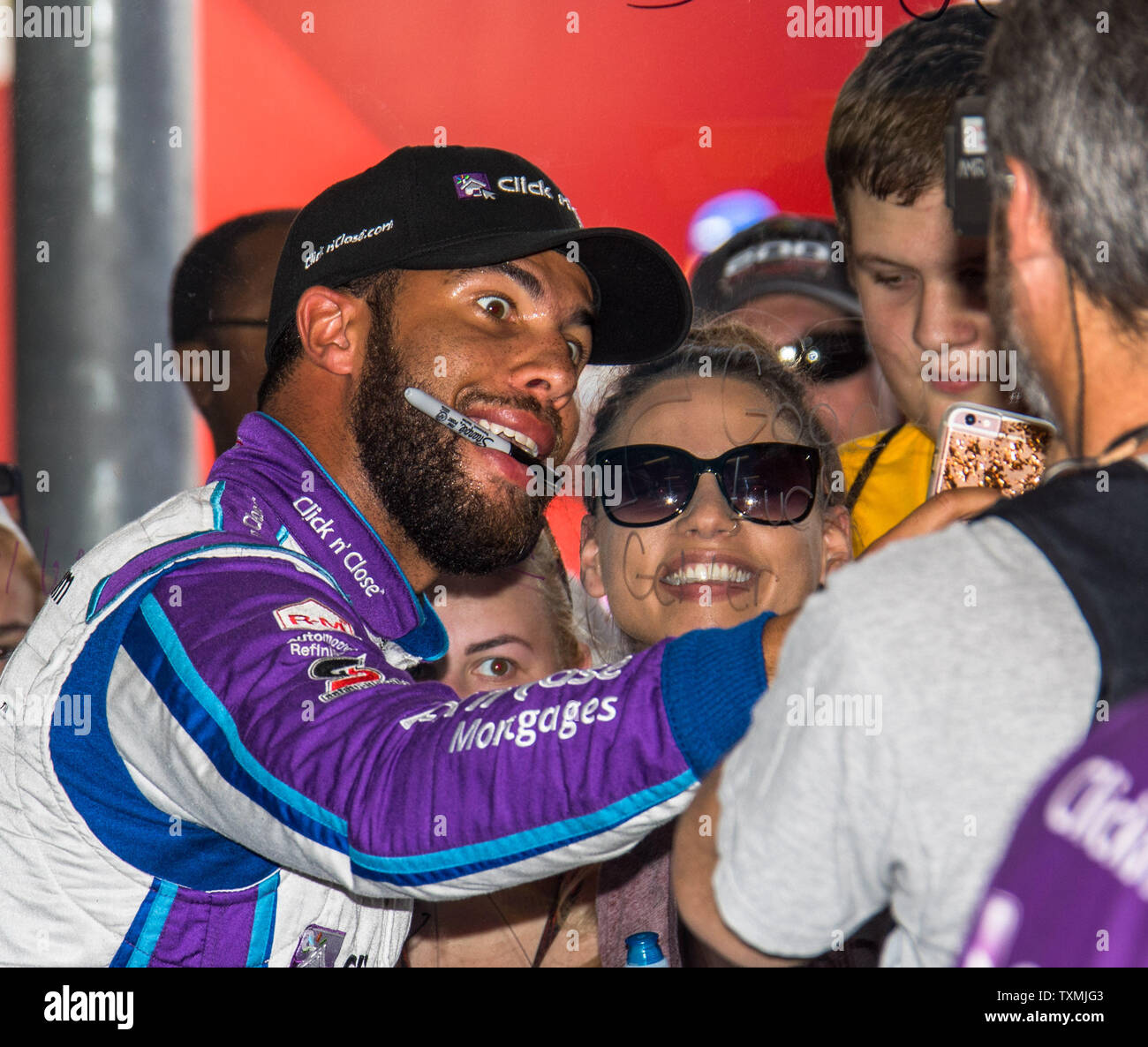 Darrell Wallace Jr poses with a fan after setting fast time in the ...