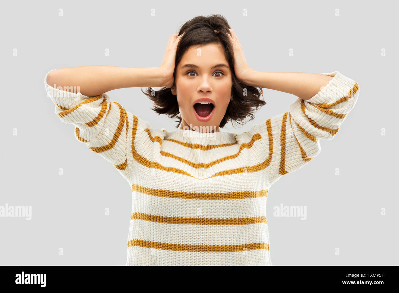 impressed woman in pullover holding to her head Stock Photo - Alamy