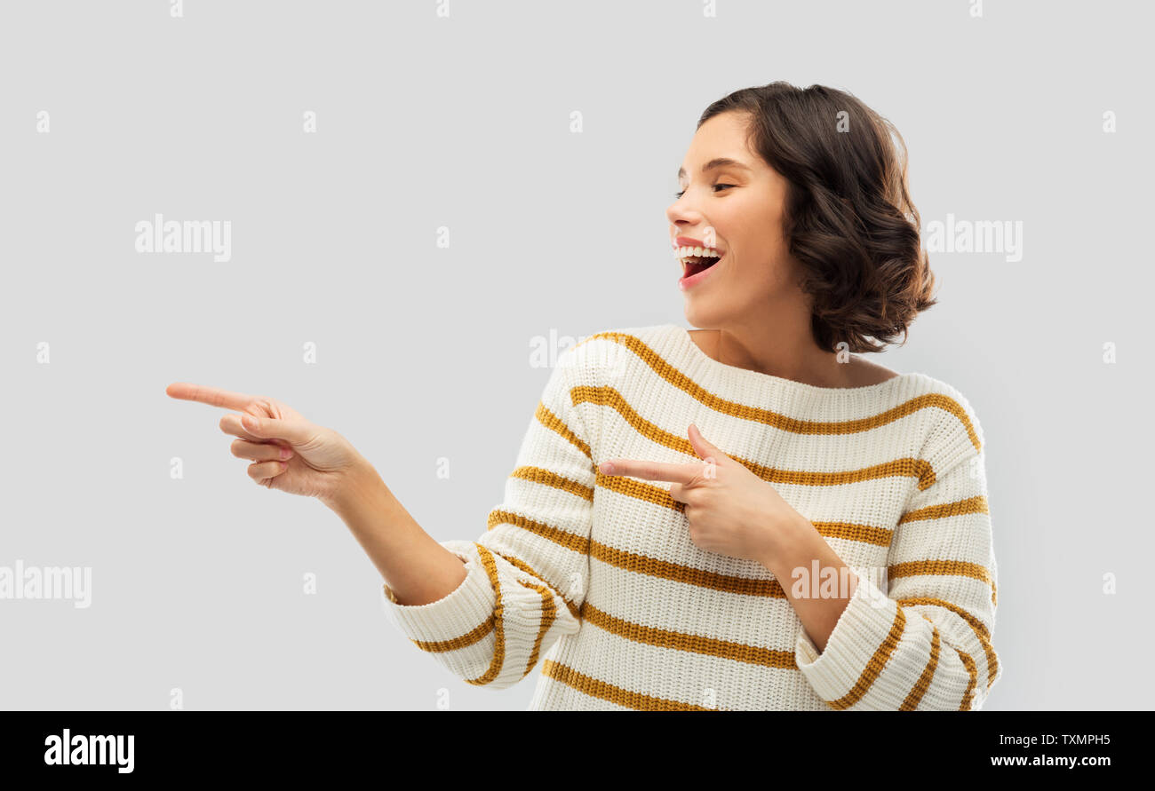 happy smiling woman pointing fingers to something Stock Photo - Alamy