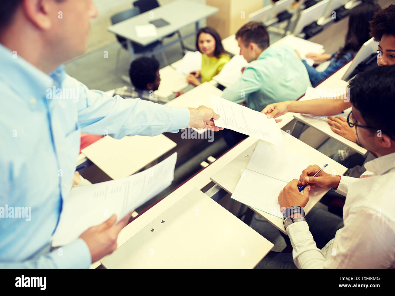teacher giving tests to students at lecture hall Stock Photo - Alamy