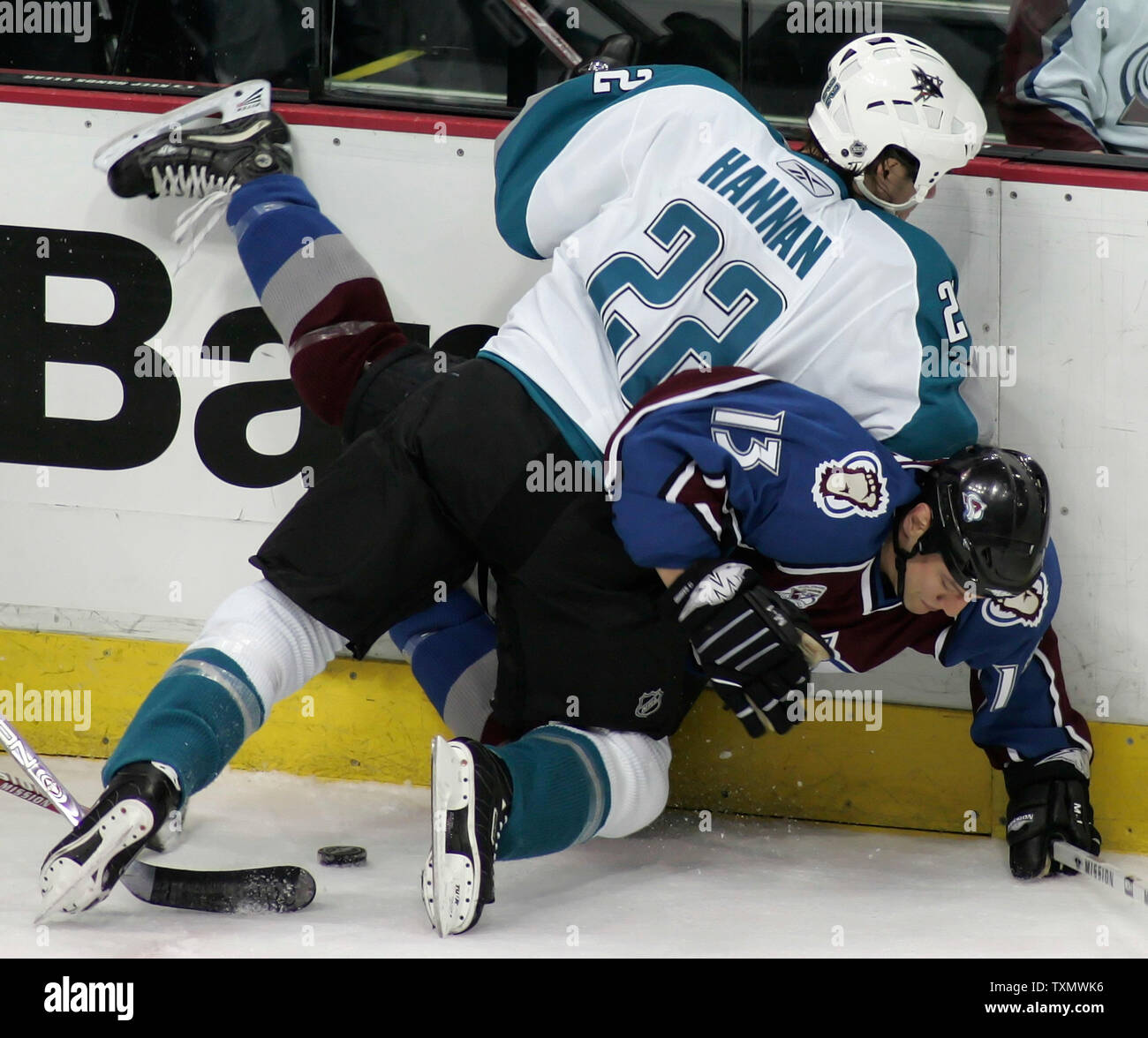 San Jose Sharks defenseman Scott Hannan (top) topples Colorado ...