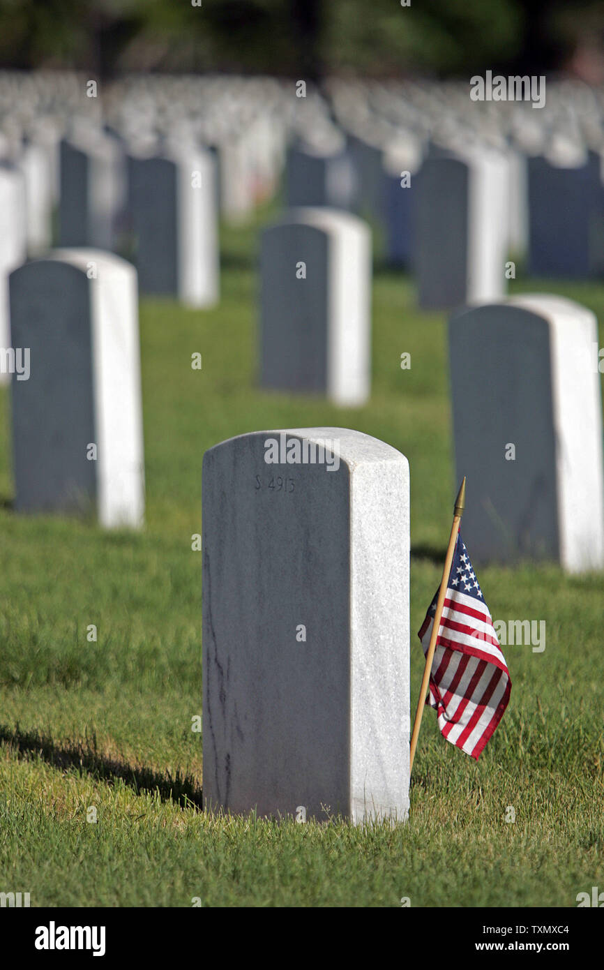 An Amercian Flag stands alongside a gravesite during Memorial Day ...