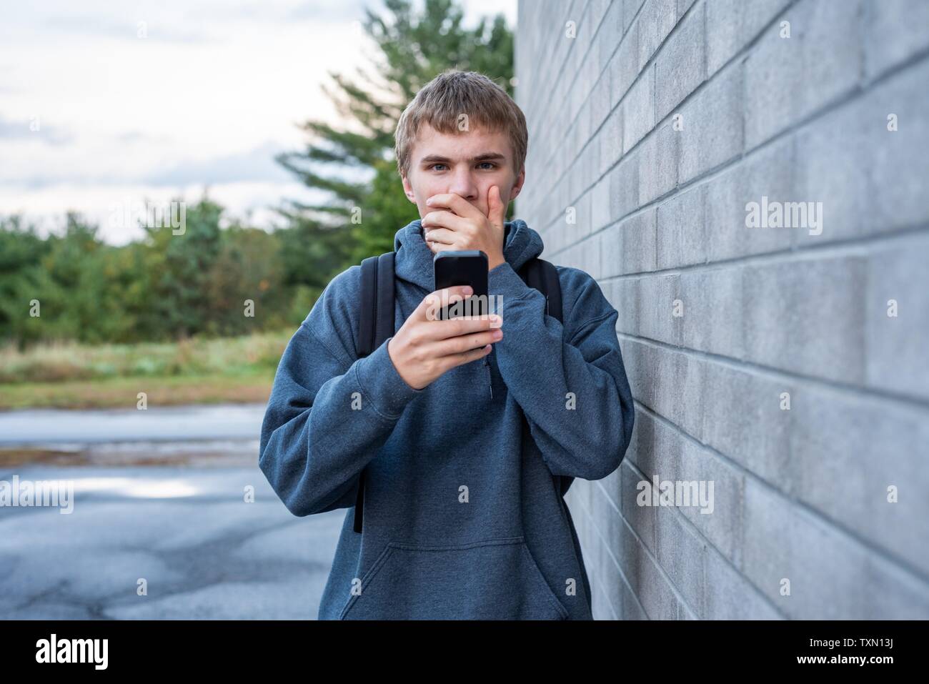Teenager viewing something upsetting on his cellphone Stock Photo - Alamy