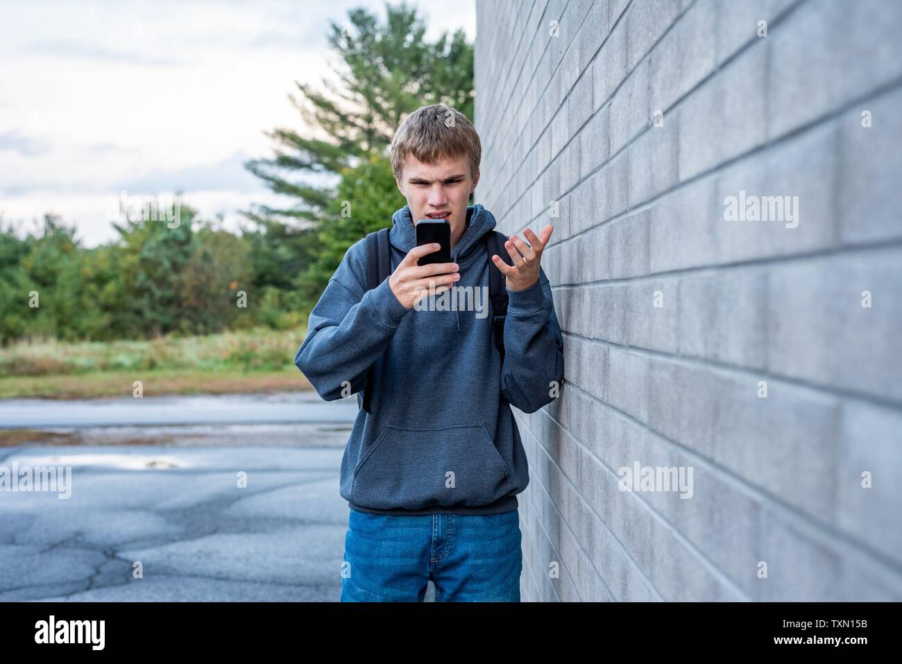 Teenager viewing something upsetting on his cellphone Stock Photo - Alamy