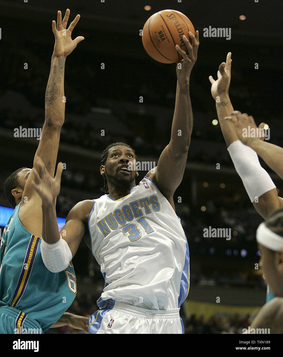 Denver Nuggets forward Nene (R) of Brazil scores against New Orleans ...