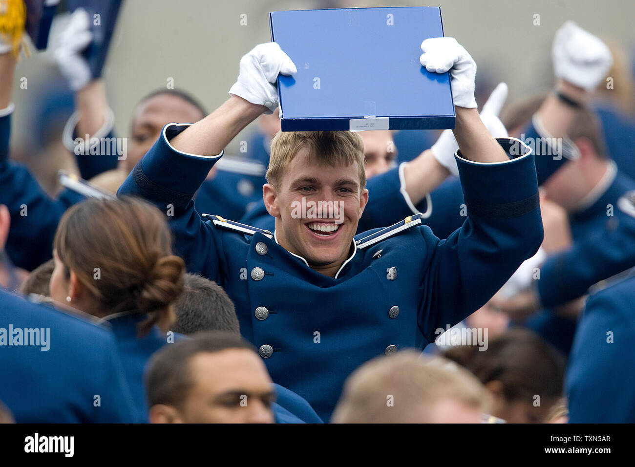 A graduating Air Force cadet celebrates after receiving his diploma at ...