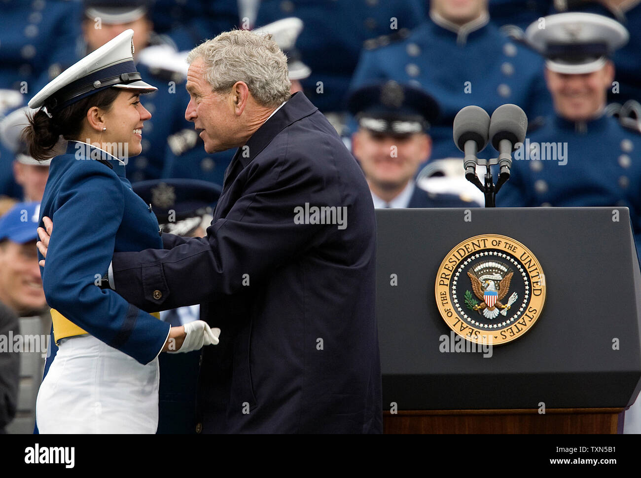 U.S. President George W. Bush (R) hugs graduating Air Force cadet at ...