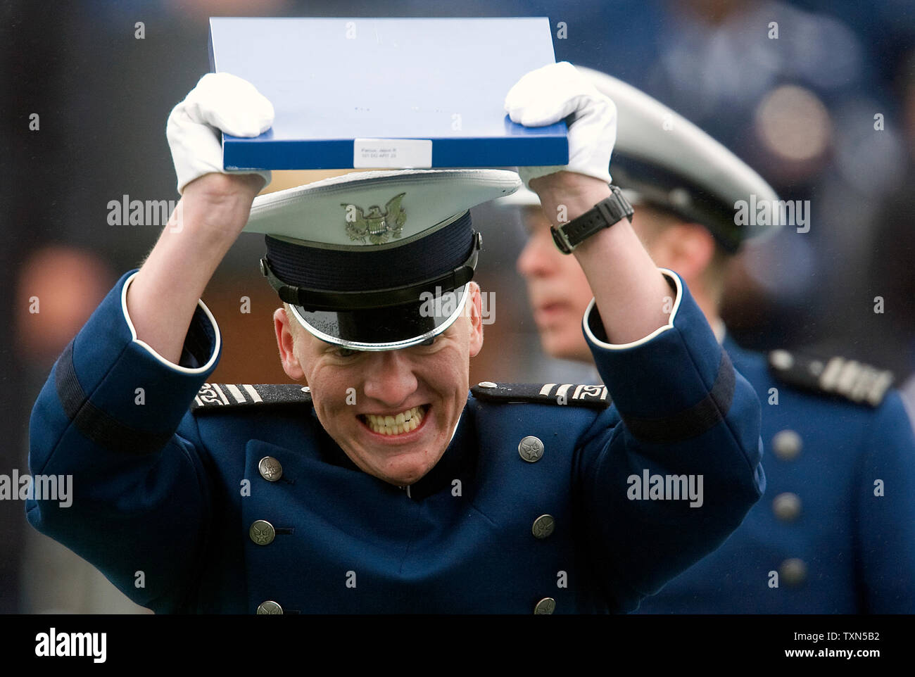 A graduating Air Force cadet celebrates receiving his diploma at the ...
