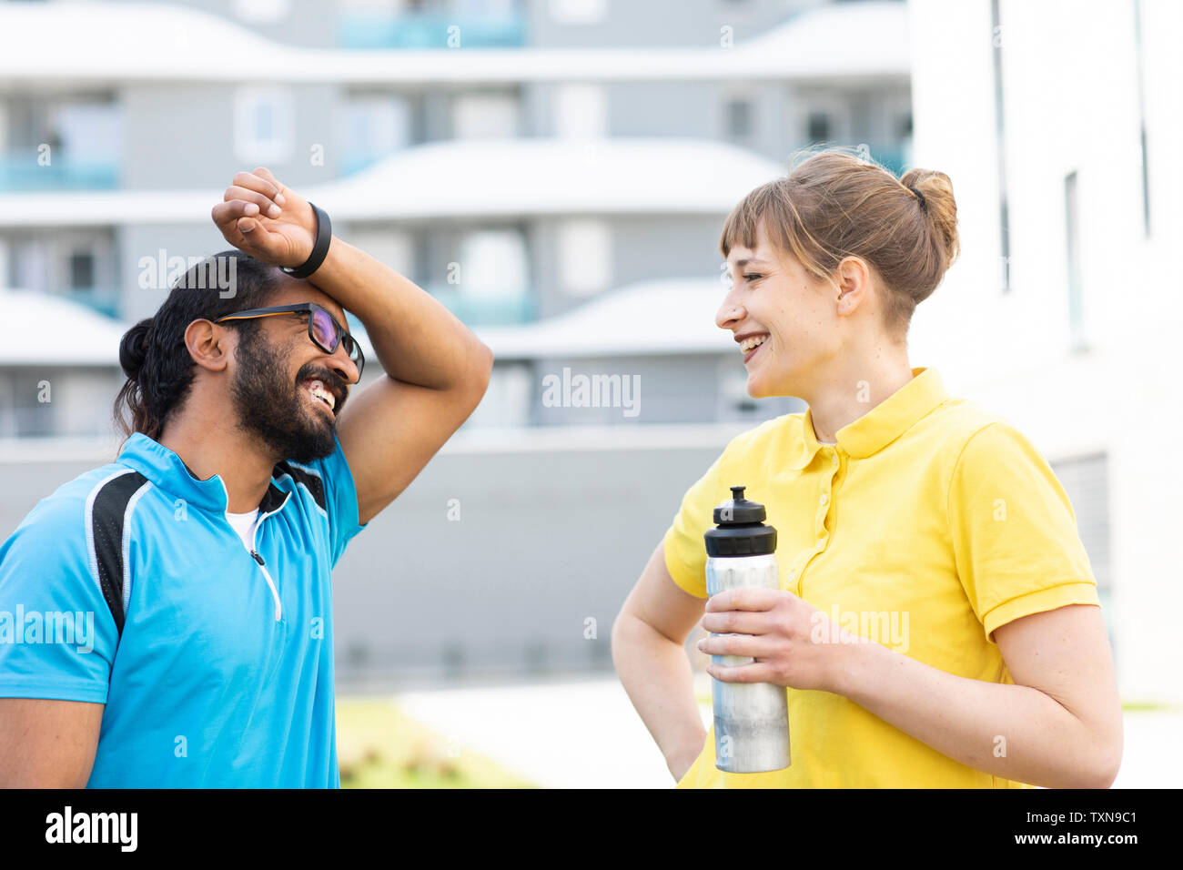Multi-ethnic couple taking break after exercise Stock Photo - Alamy