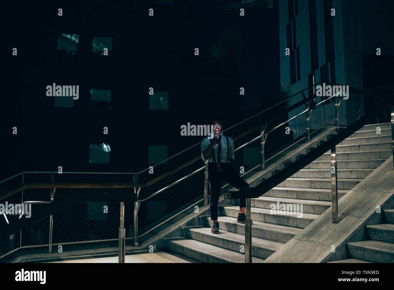 Businessman using smartphone on stairs of office building Stock Photo ...