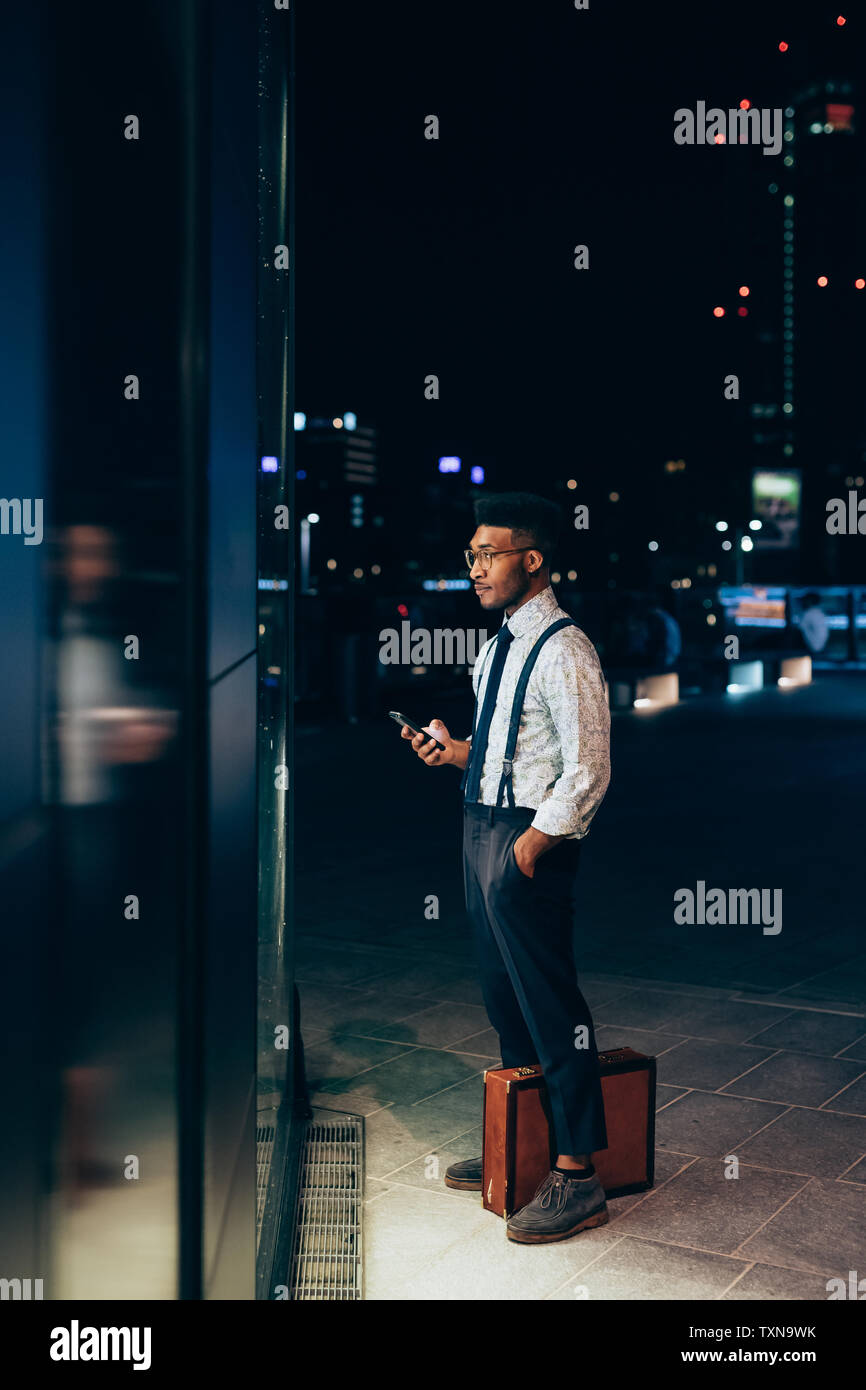 Businessman looking into window of shop Stock Photo - Alamy