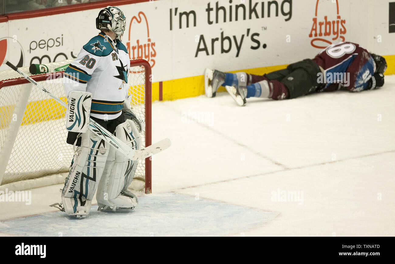 San Jose Sharks goalie Evgeni Nabokov (20 looks over at fallen Colorado ...